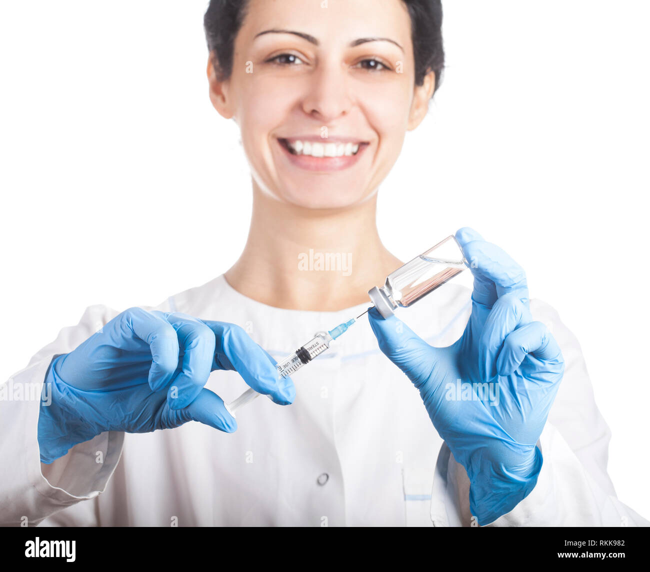 A syringe and a bottle with an injection solution.The smiling doctor is ...