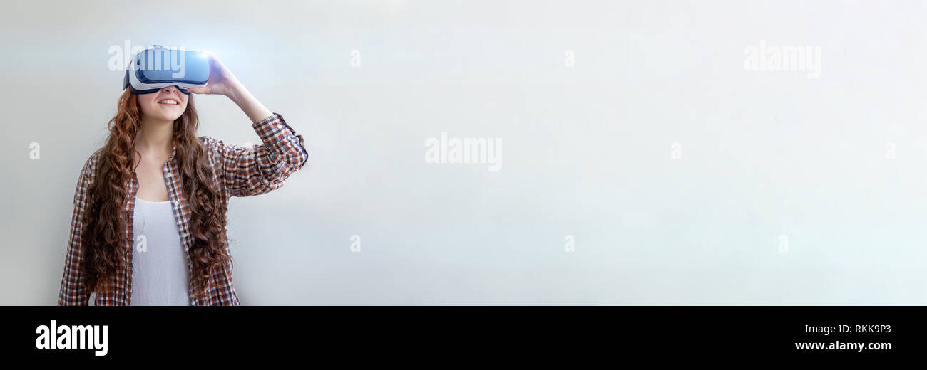 Technology, simulation, hi-tech, videogame concept. Young woman wearing using virtual reality VR ...