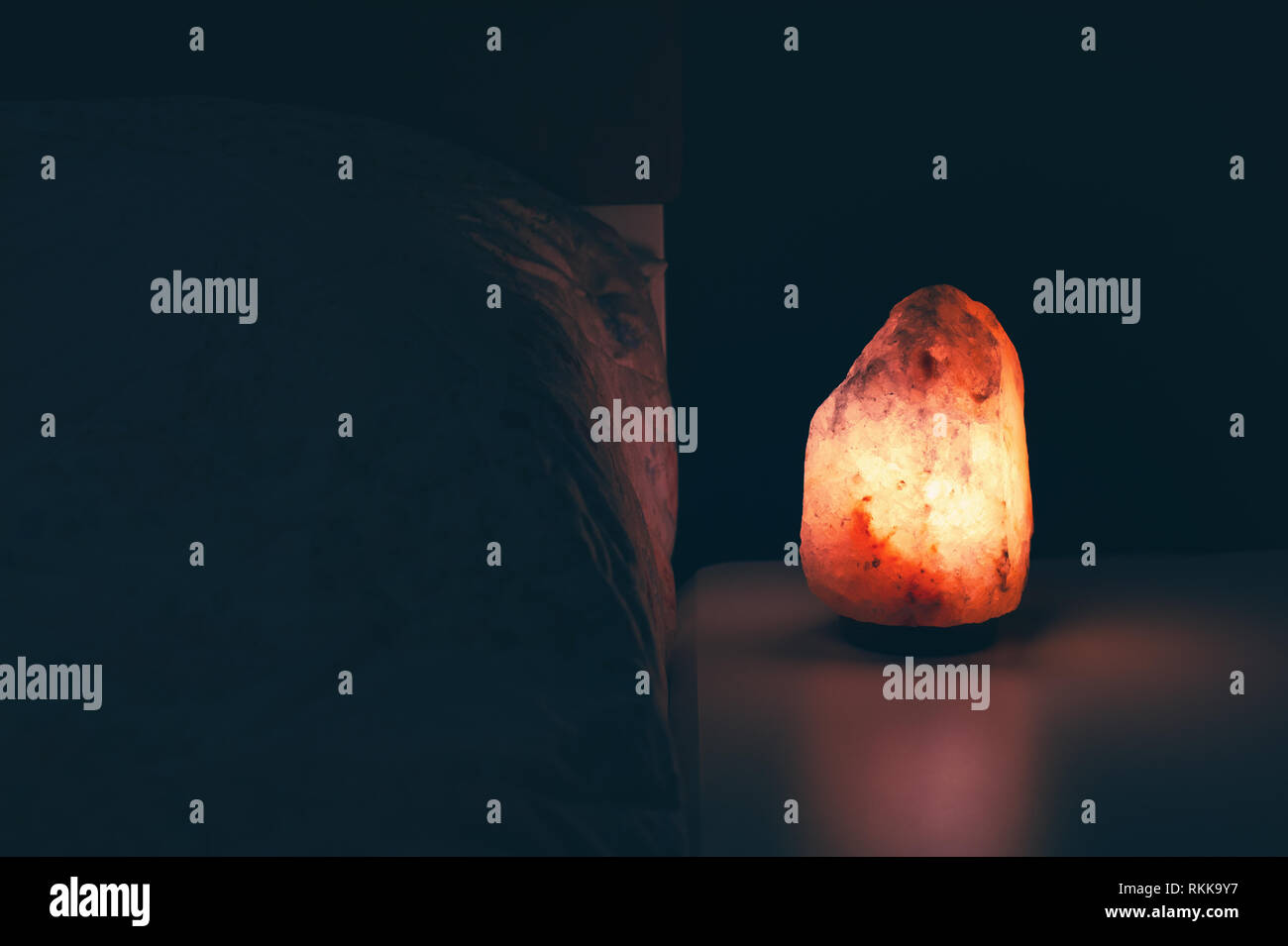 Himalayan salt lamp glowing on dark background with space for text ...