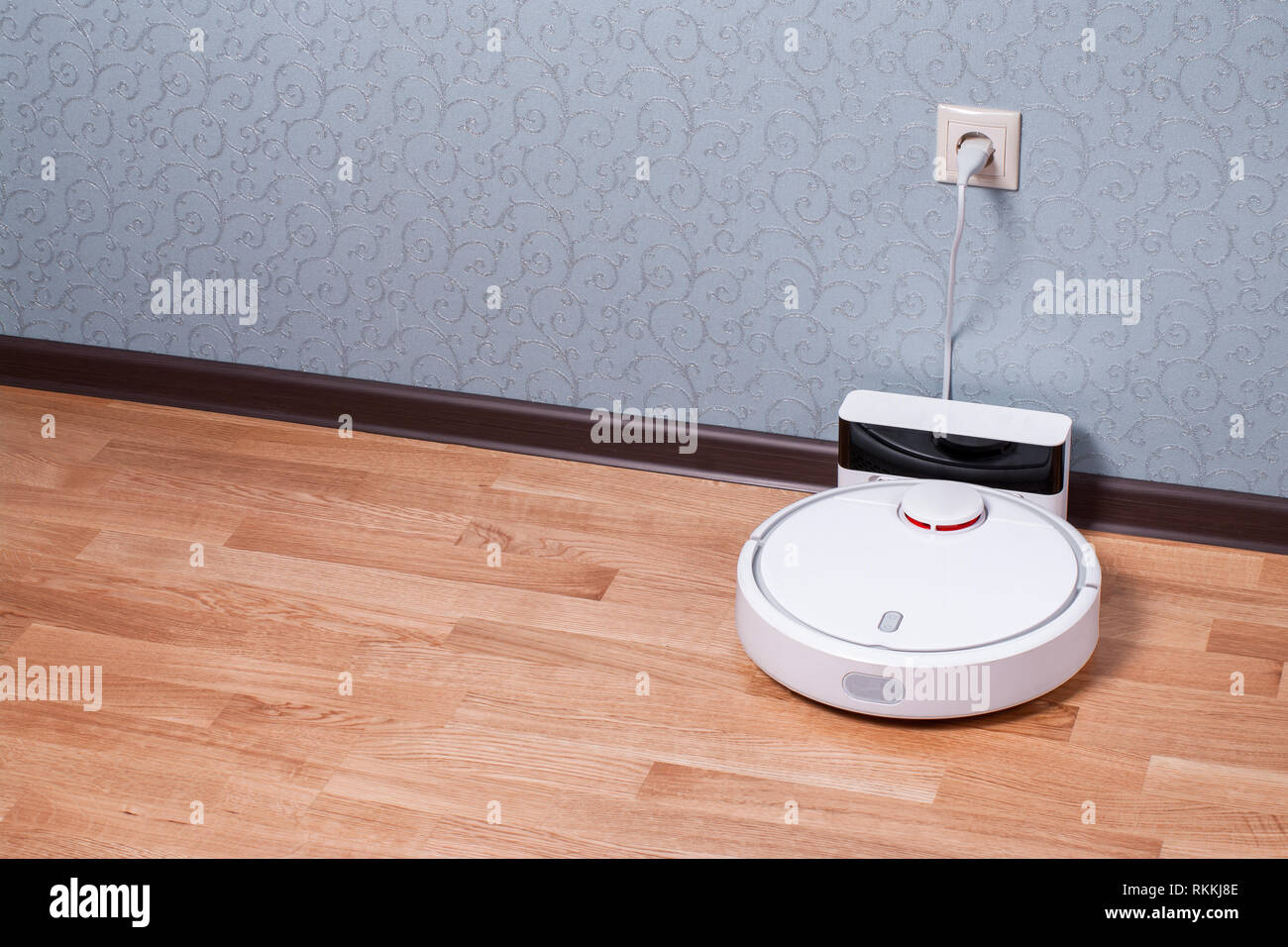 Robot vacuum cleaner on charging dock after it is finished. Modern ...