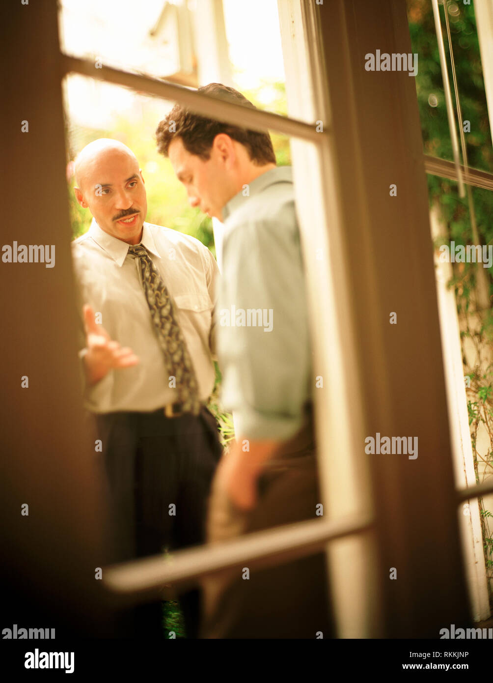 Side view of two men engaged in a serious discussion Stock Photo - Alamy