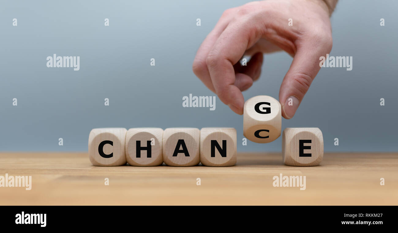 Hand flips a dice and changes the word "change" to "chance Stock Photo ...