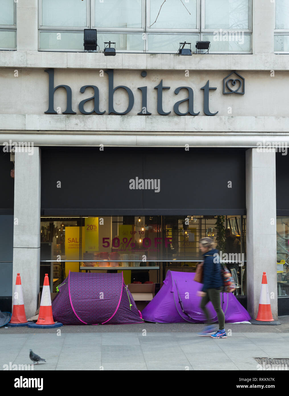 Young people walk past homeless people's tents pitched outside Habitat ...
