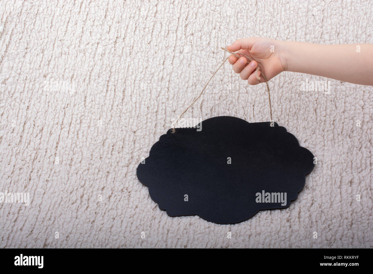 Black speech bubble shaped notice board in hand on white background ...
