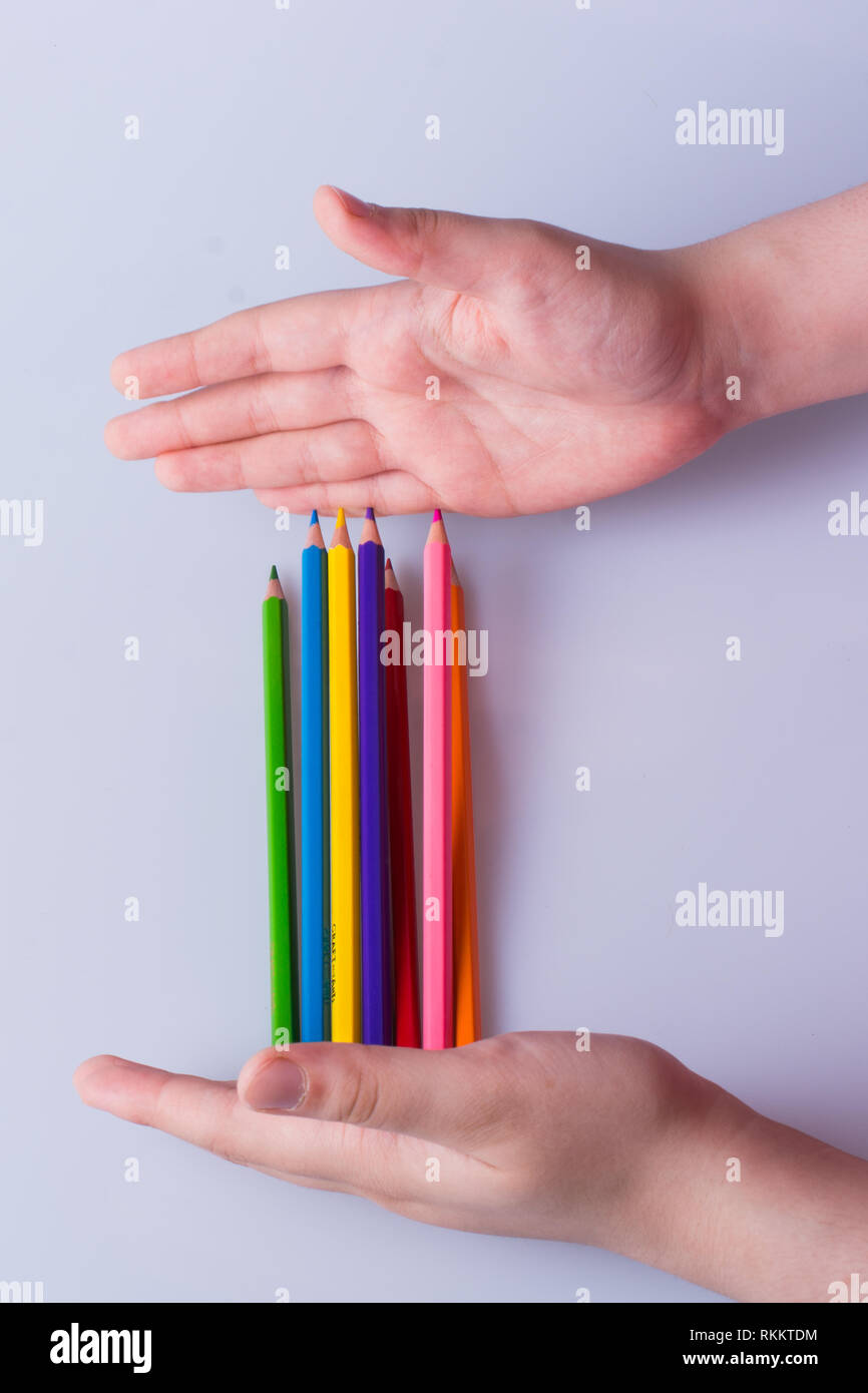 Hand holding color Pencils placed on a white background Stock Photo - Alamy