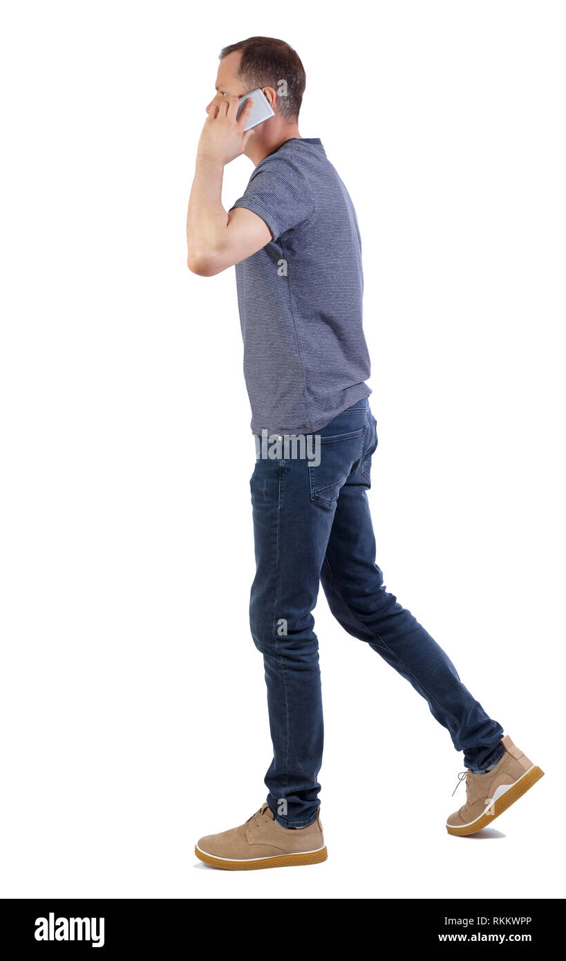 a side view of man walking with a mobile phone. backside view of person ...
