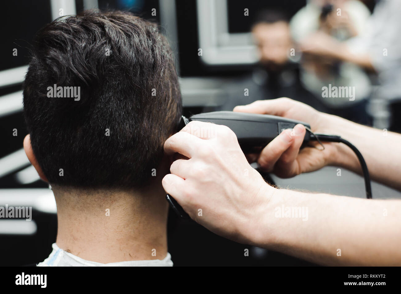 Master cuts hair and beard of men in the barbershop, hairdresser Stock ...