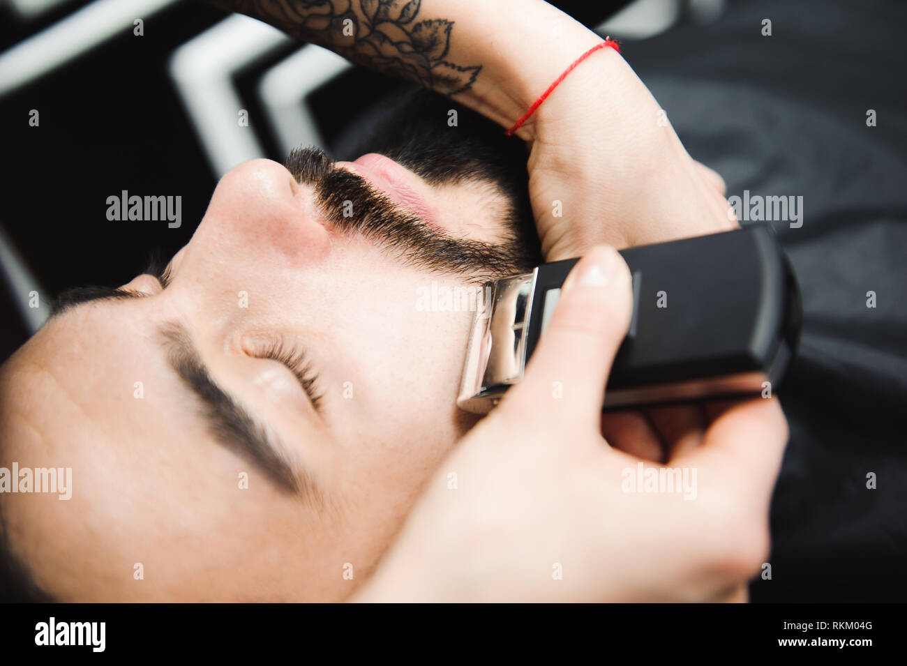 Master cuts hair and beard of men in the barbershop, hairdresser Stock ...