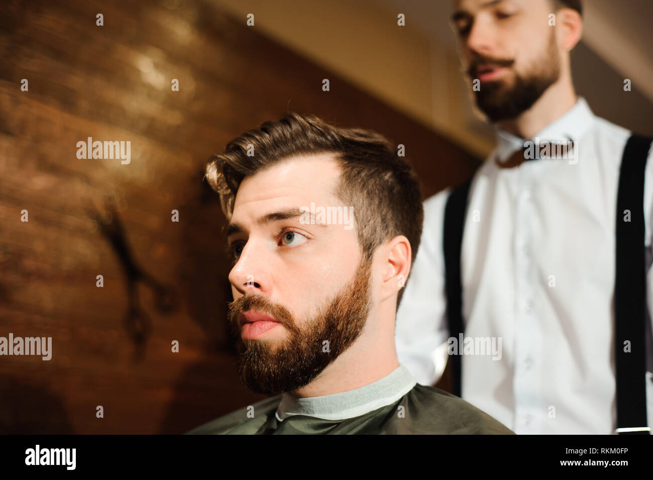 Master cuts hair and beard of men in the barbershop Stock Photo - Alamy