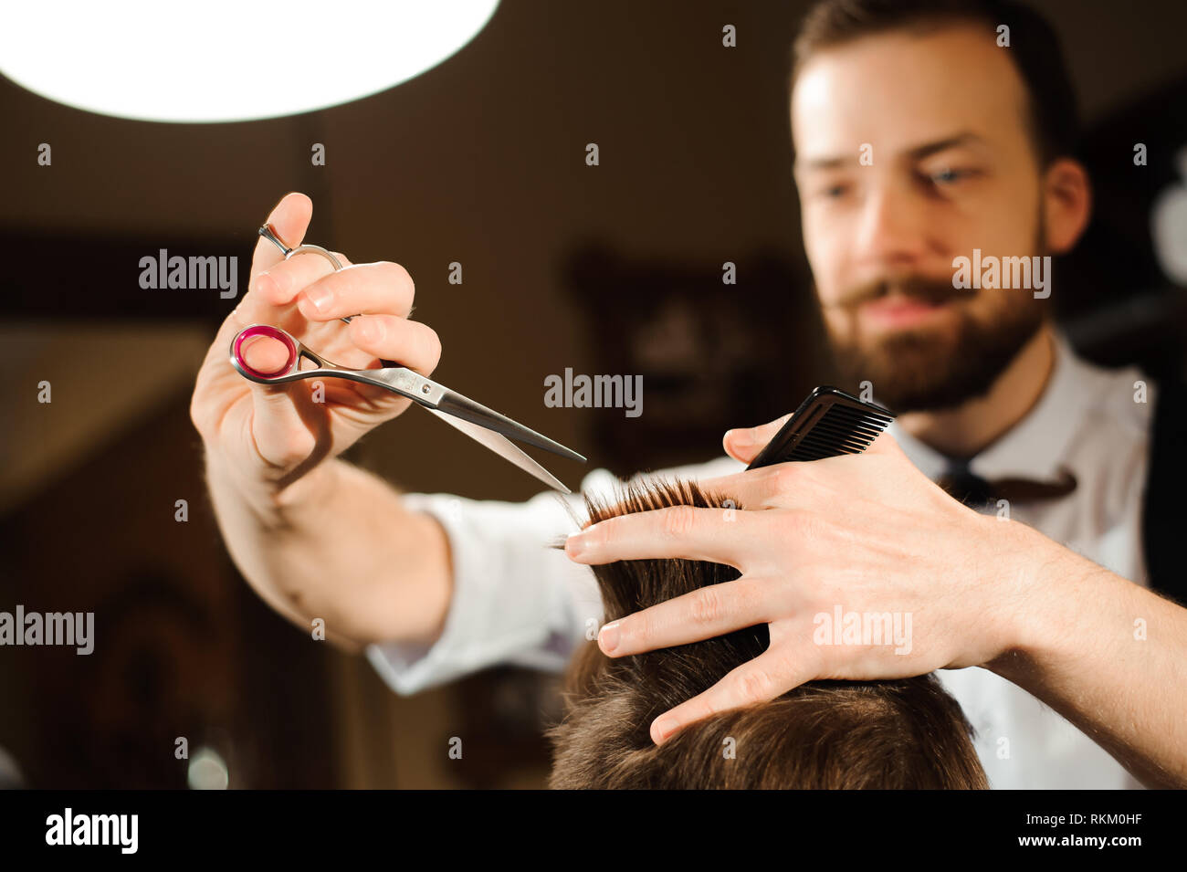 Master cuts hair and beard of men in the barbershop Stock Photo - Alamy