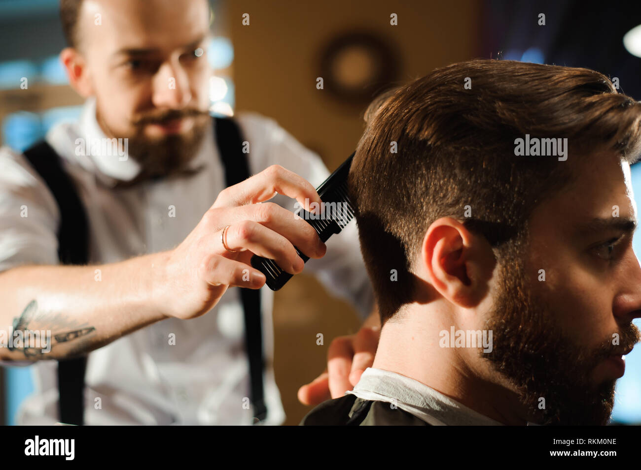 Master cuts hair and beard of men in the barbershop Stock Photo - Alamy