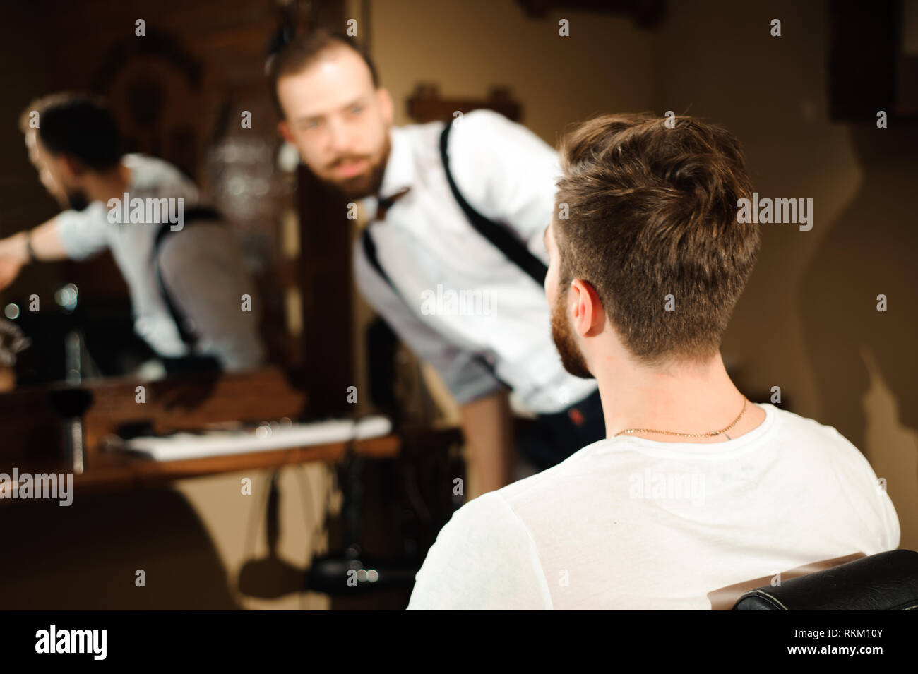 Master cuts hair and beard of men in the barbershop Stock Photo - Alamy