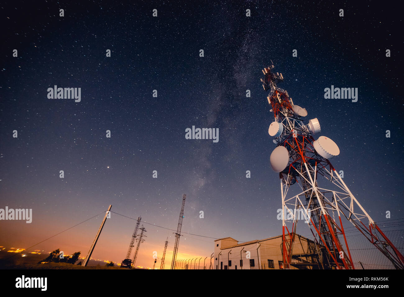 From below tall modern radio tower located against majestic starry sky ...