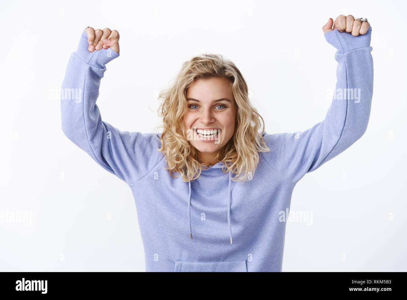 Girl cheering with enthusiasm raising hands up in victory and joy ...