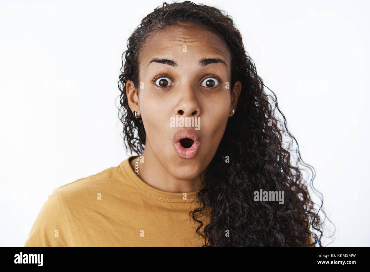 Headshot of impressed and thrilled surprised dark-skinned girl with ...