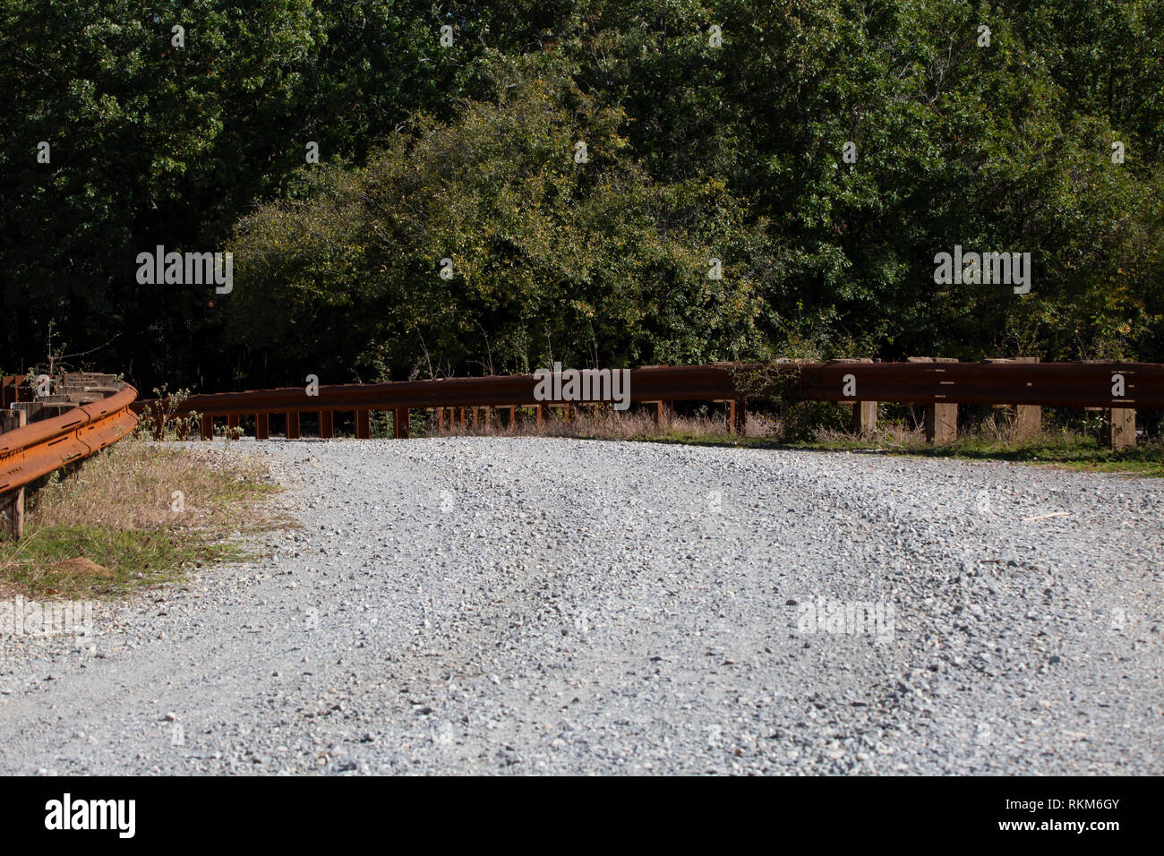 Rusty iron bridge guardrail on a gravel road Stock Photo - Alamy