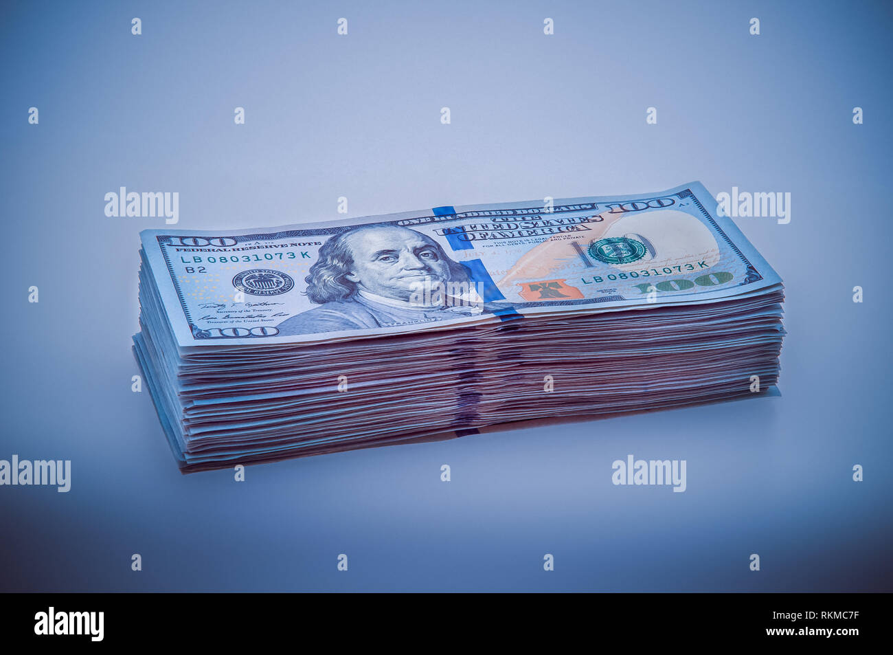 A big stack of hundred-dollar bills. Blue design. Vignetting Stock ...