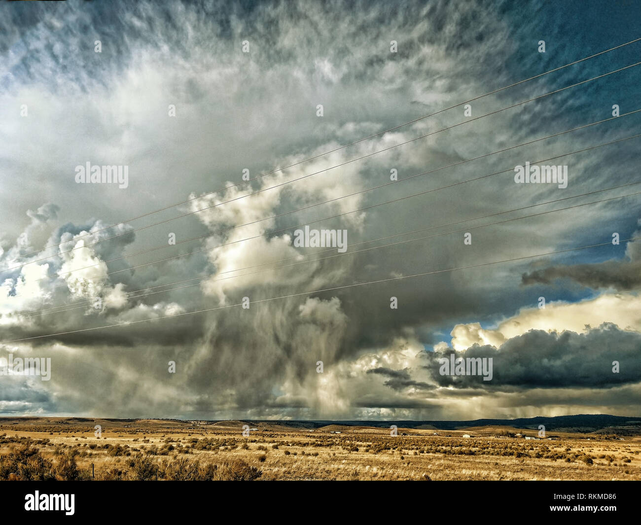 High wire powerlines slice across stormy rain clouds in southeastern ...