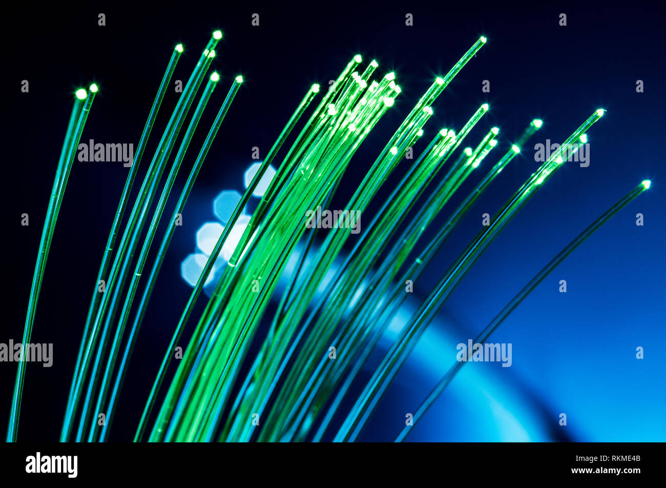 Bundle of optical fibers with green light. Blue background Stock Photo ...