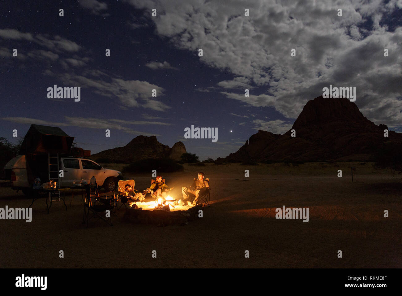 Family at campfire while desert camping under the stars, Spitzkoppe ...