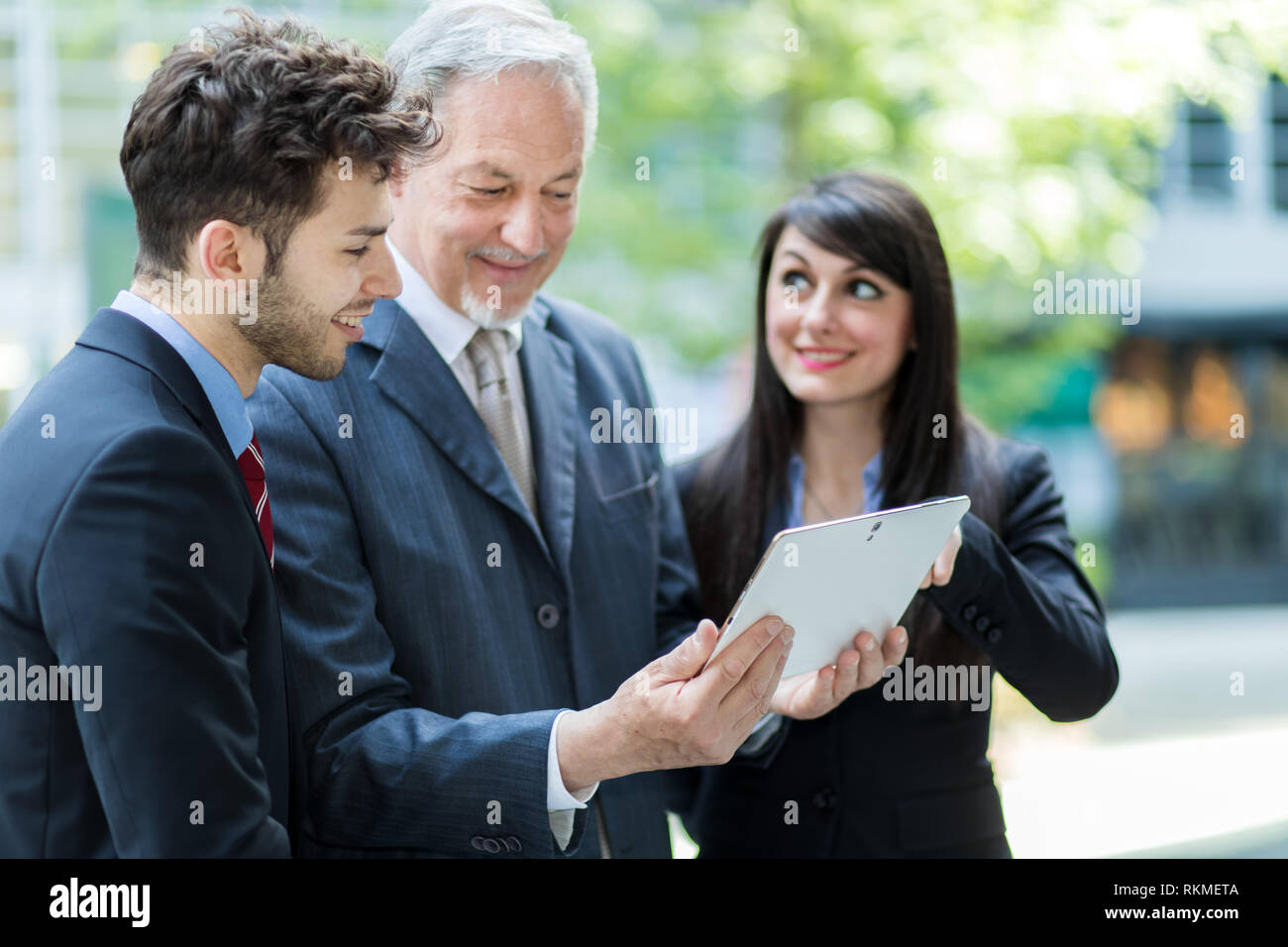 Business people using a tablet outdoor Stock Photo - Alamy
