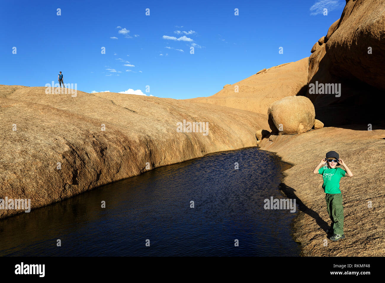 Mother and son standing at natural pool at the natural rock arch near ...