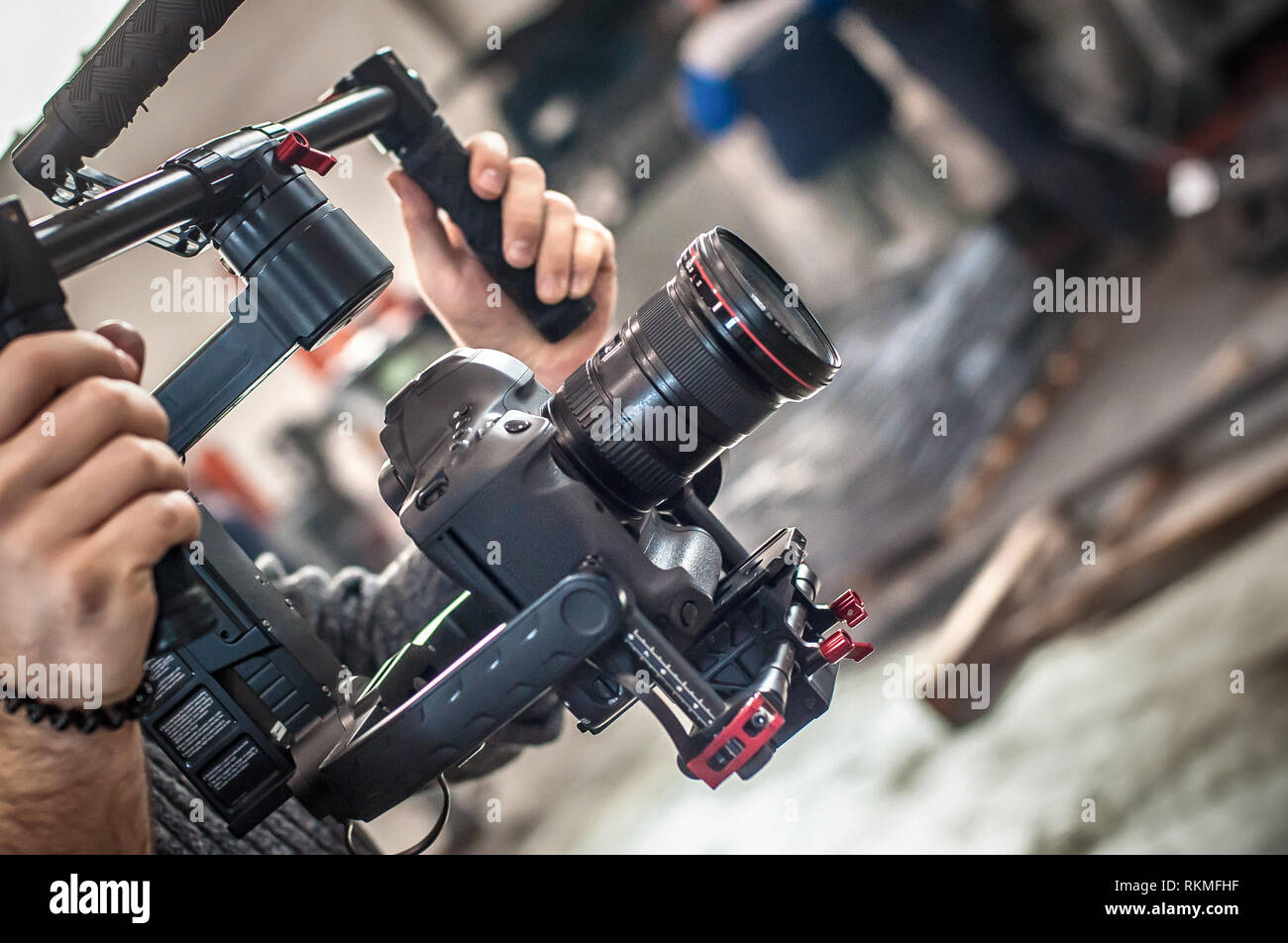 Videographer using stadicam, making video of machine at factory. Close ...