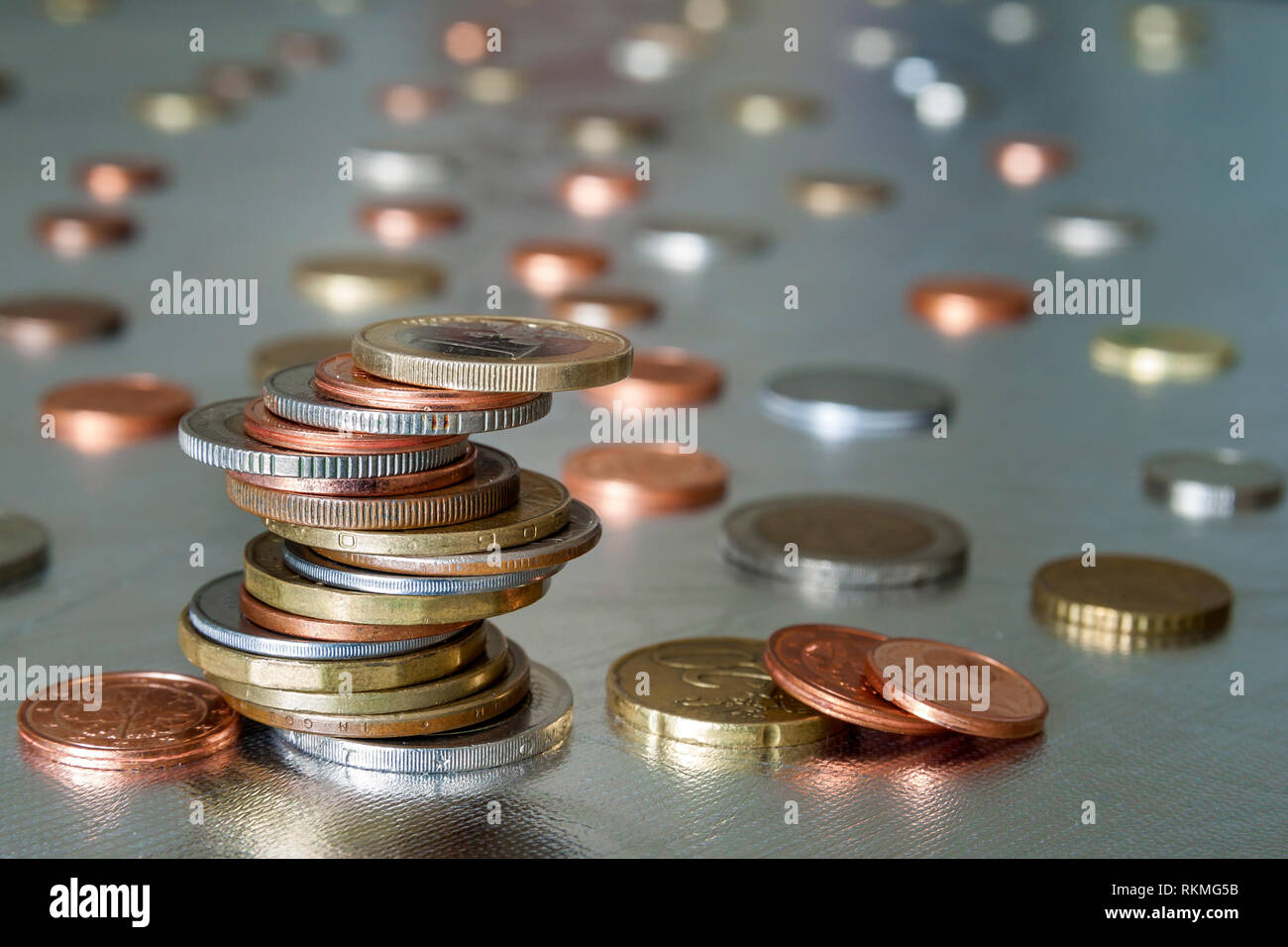Pile of shiny coins different sizes and colors stacked unevenly on each ...