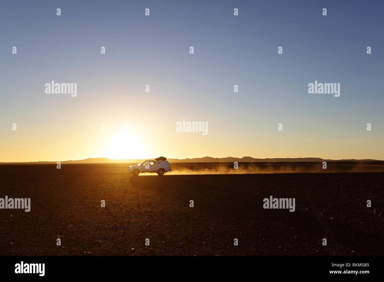 4x4 wd car driving on dry namibian desert landscape, light shining ...