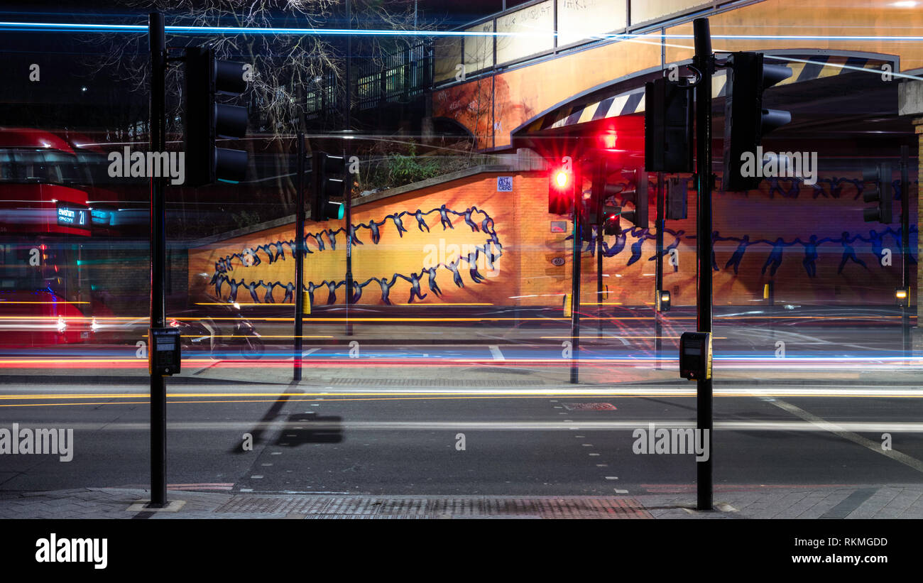 Night trafic in London Lewisham area with red bus passing and lines ...