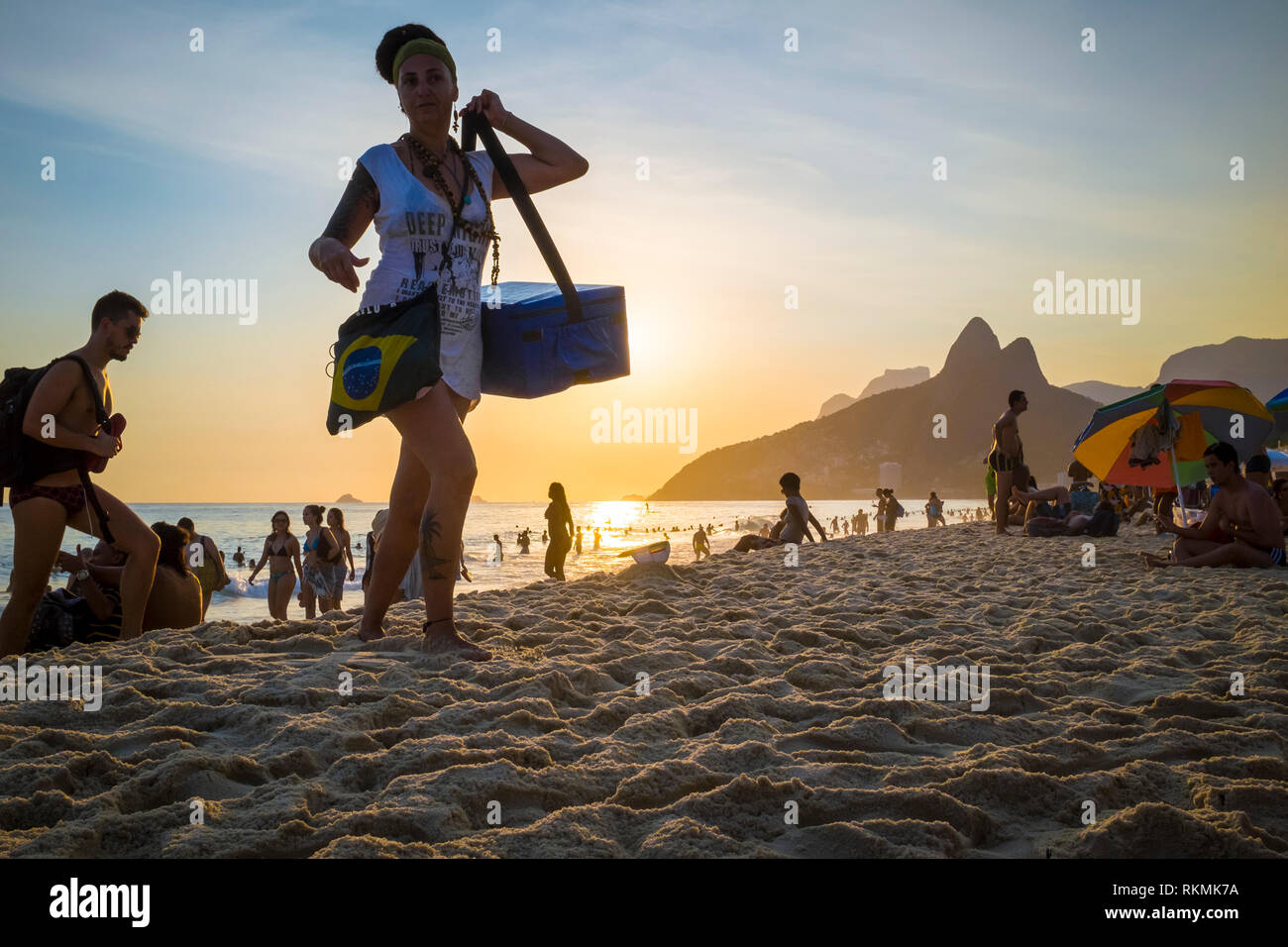 RIO DE JANEIRO - JANUARY, 2015: A beach vendor carries snacks in a ...