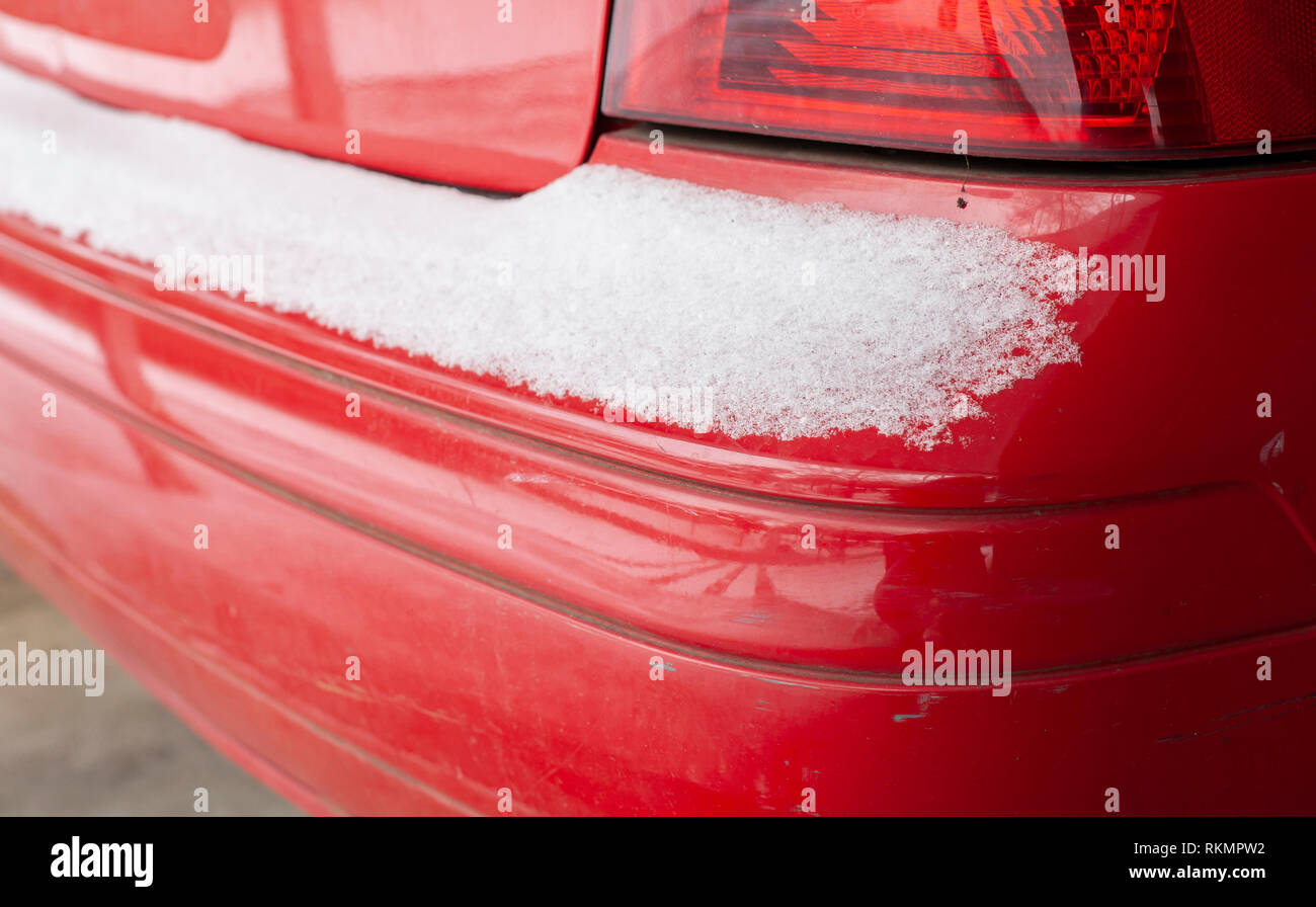 Snow lightly covering the red bumper of a vehicle Stock Photo - Alamy