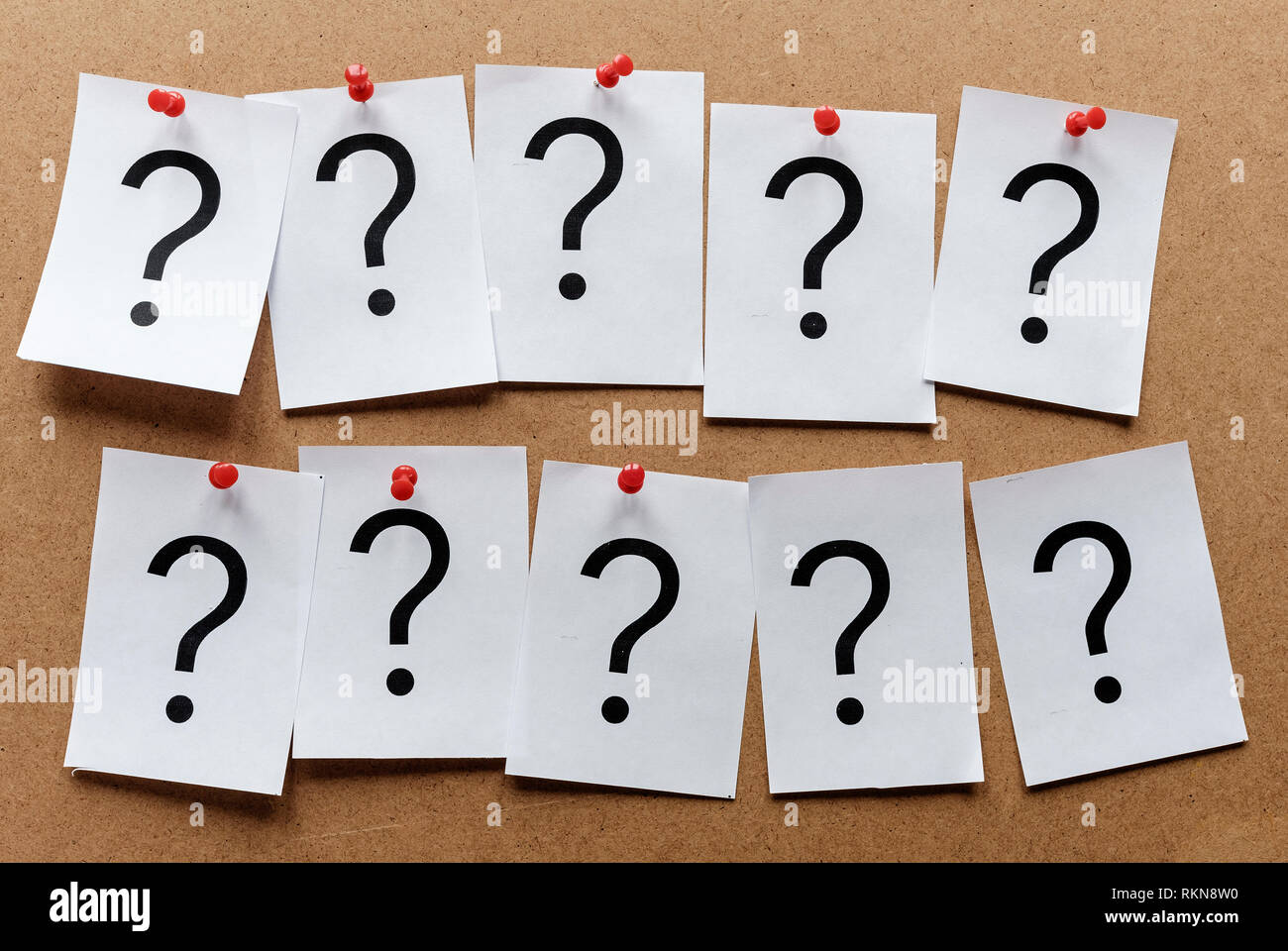 Two rows of question marks printed on individual white cards pinned to ...