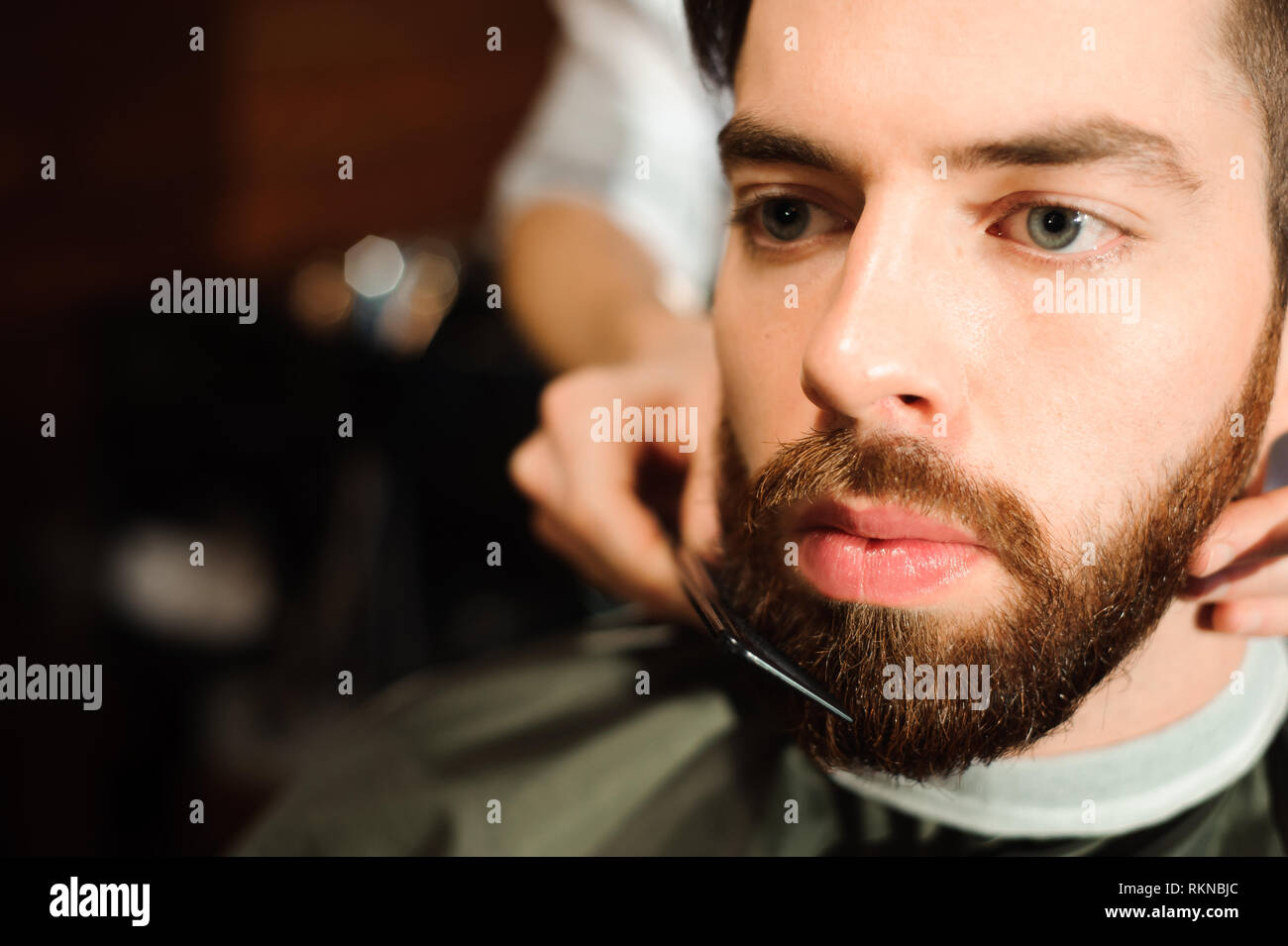 Master cuts hair and beard of men in the barbershop Stock Photo - Alamy