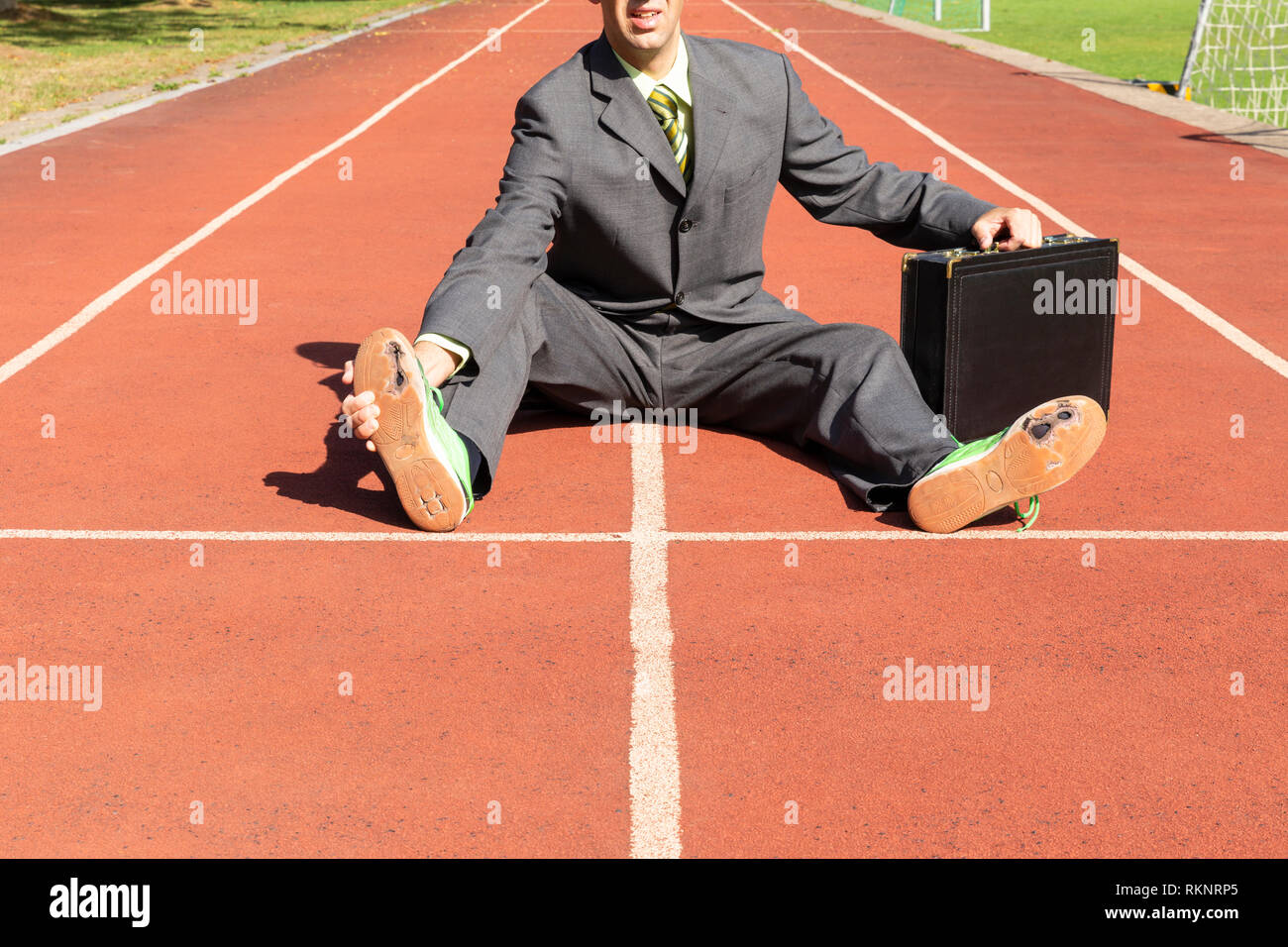 An exhausted business man in gray suit with green shirt and tie, black ...