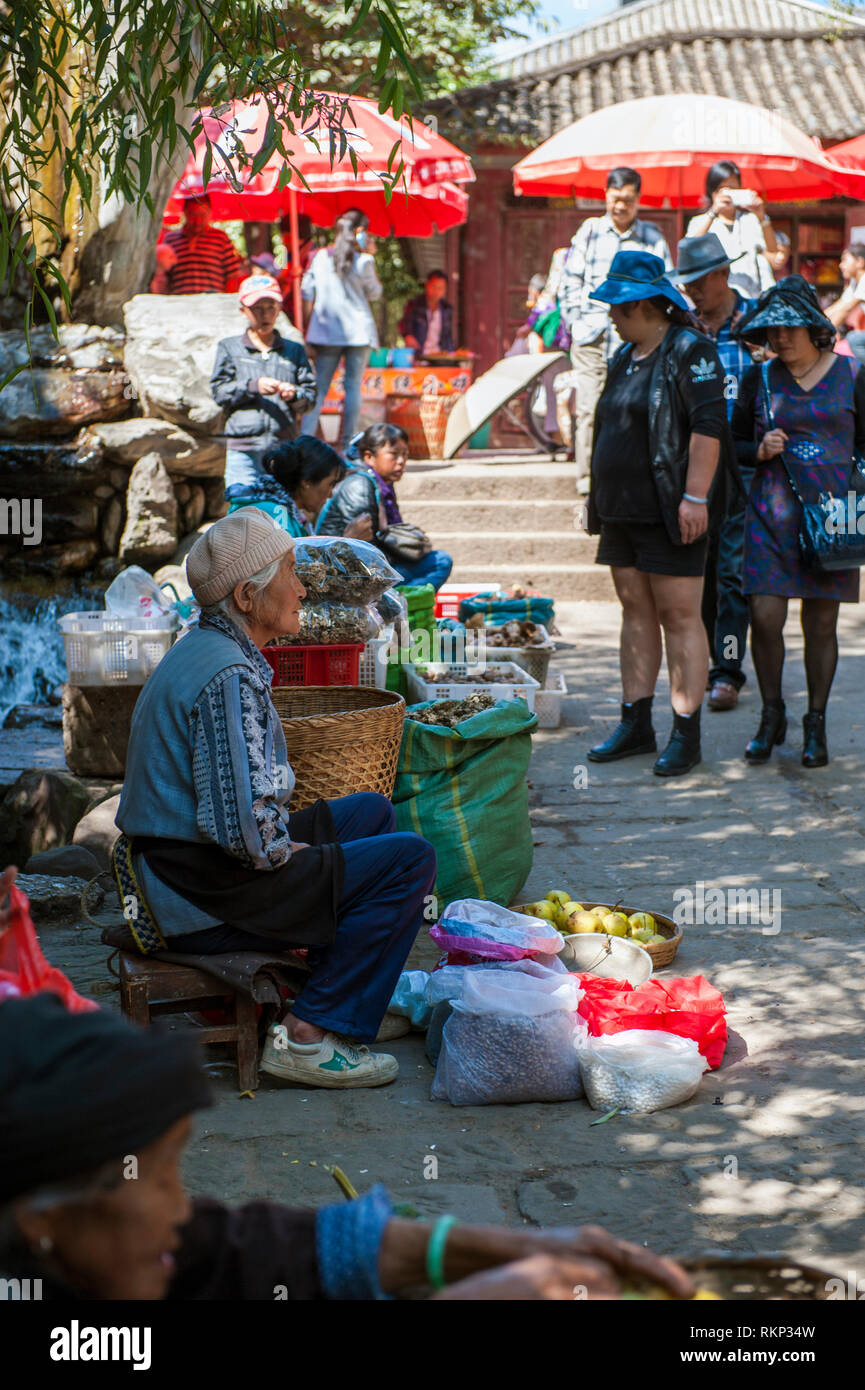 Ethnic Bai women sell fruit and snacks at a makeshift market in Shaxi ...