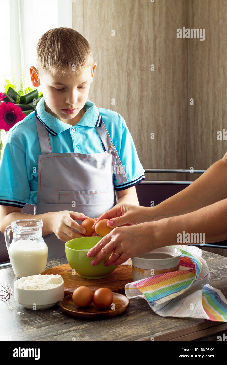 Funny happy chef boy cooking on a kitchen table and cooking dough. Food ...