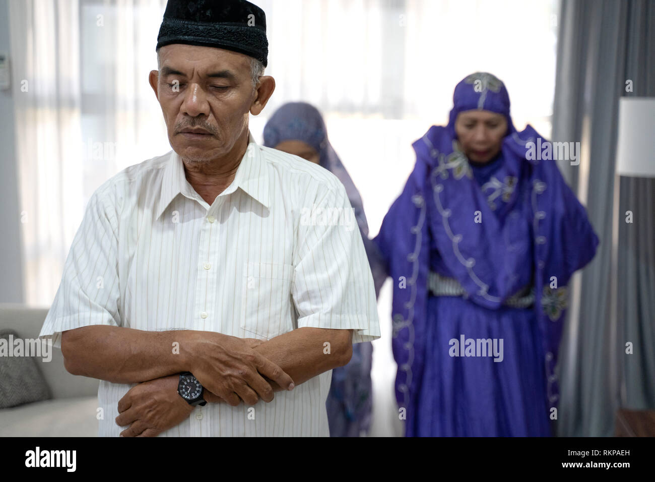 portrait of family members praying in congregation at the prayer room ...