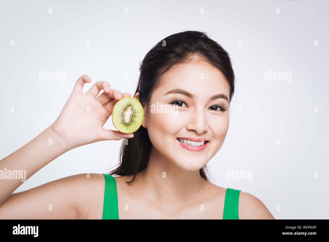 Kiwi fruit. Happy young asian woman holding kiwi fruit isolated on ...