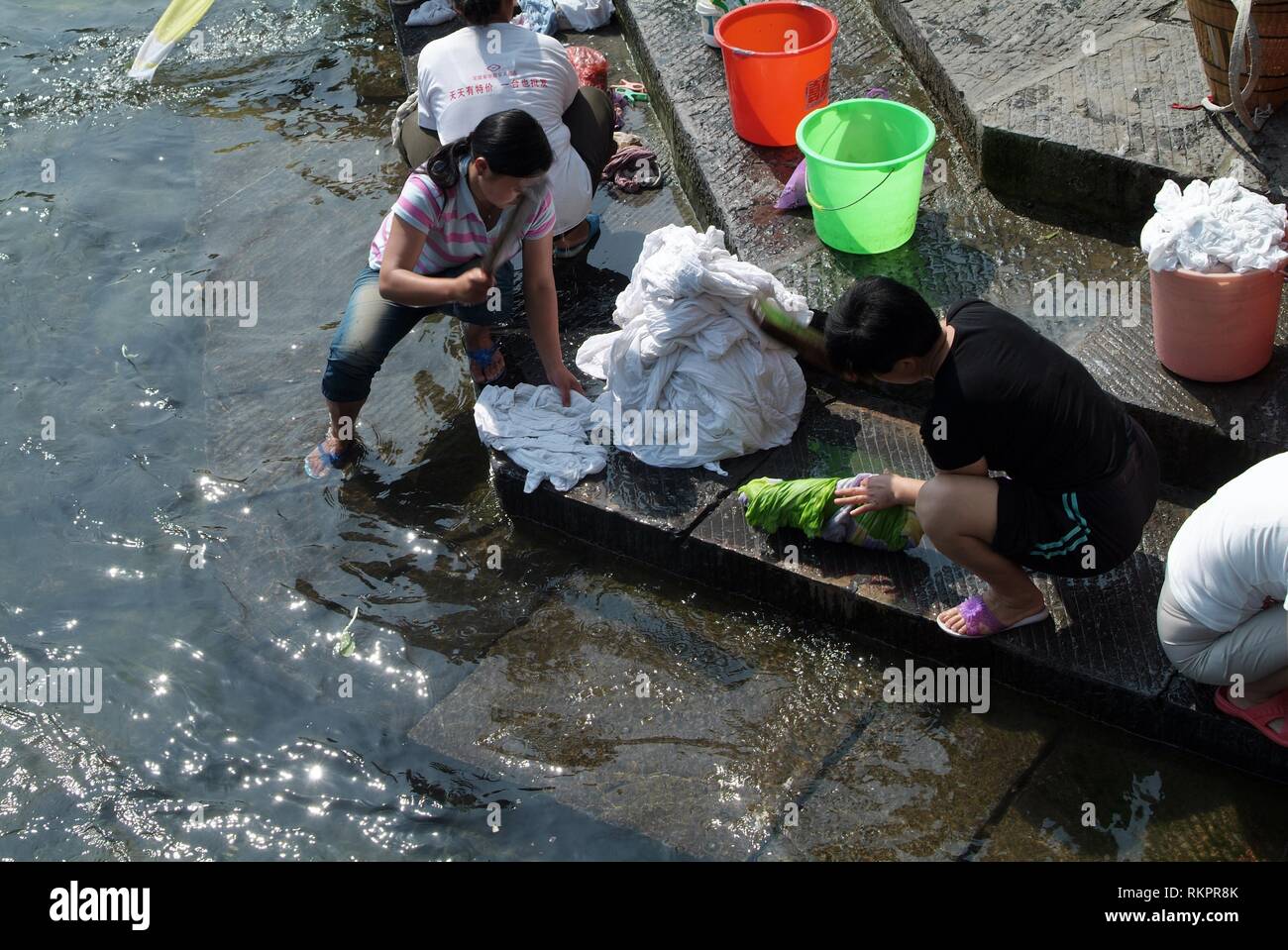 Locals washing linen and clothes in the Tou Jiang River at Fenghuang ...