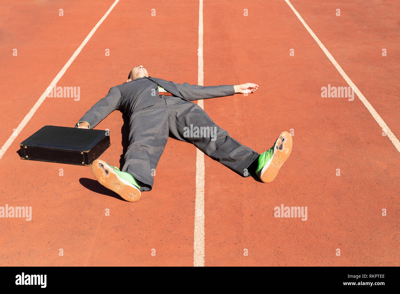 An exhausted business man in gray suit with green shirt and tie, black ...