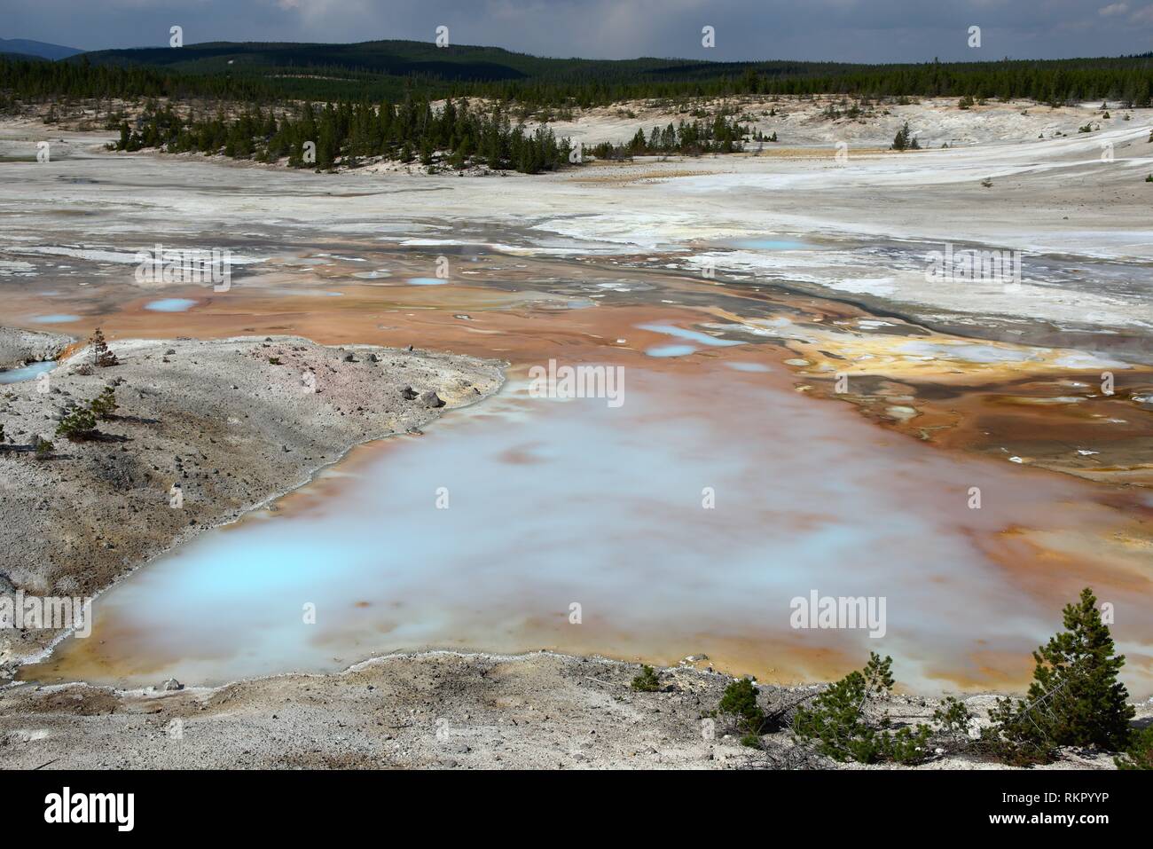A milky geyser surrounded with red and rusty soil somewhere in ...