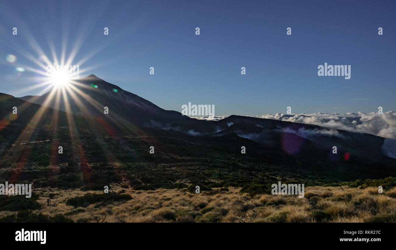 Sun behind high Teide volcano in Tenerife at sunset Stock Photo - Alamy