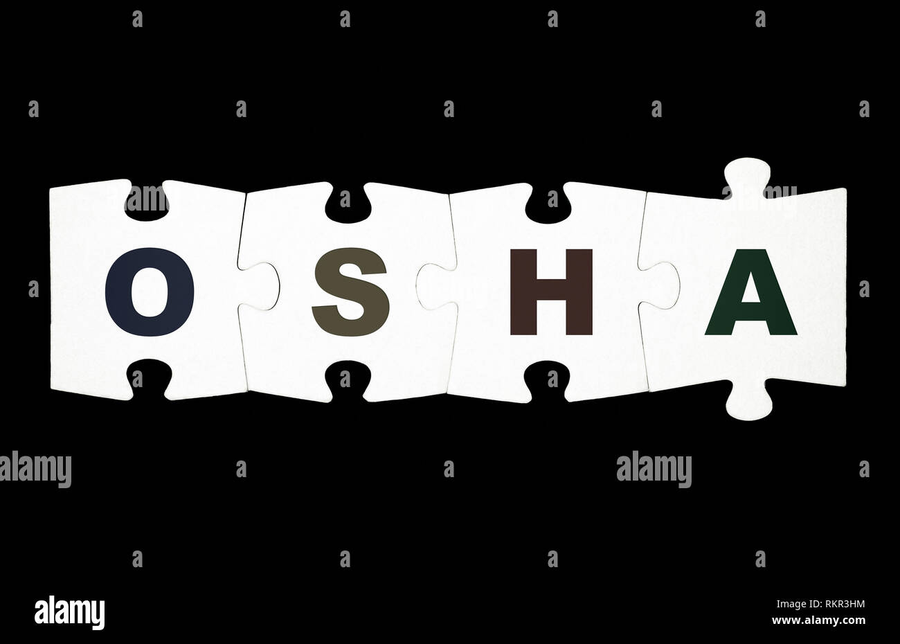 Four pieces of puzzle with letters OSHA are connected together on black ...