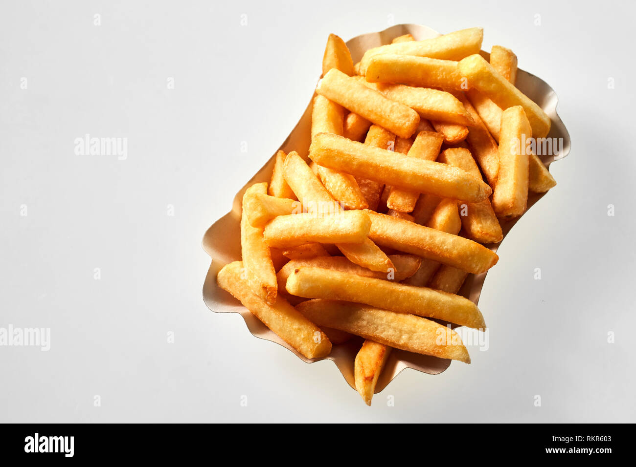 Portion of golden fried pommes frites in a fluted dish isolated on ...
