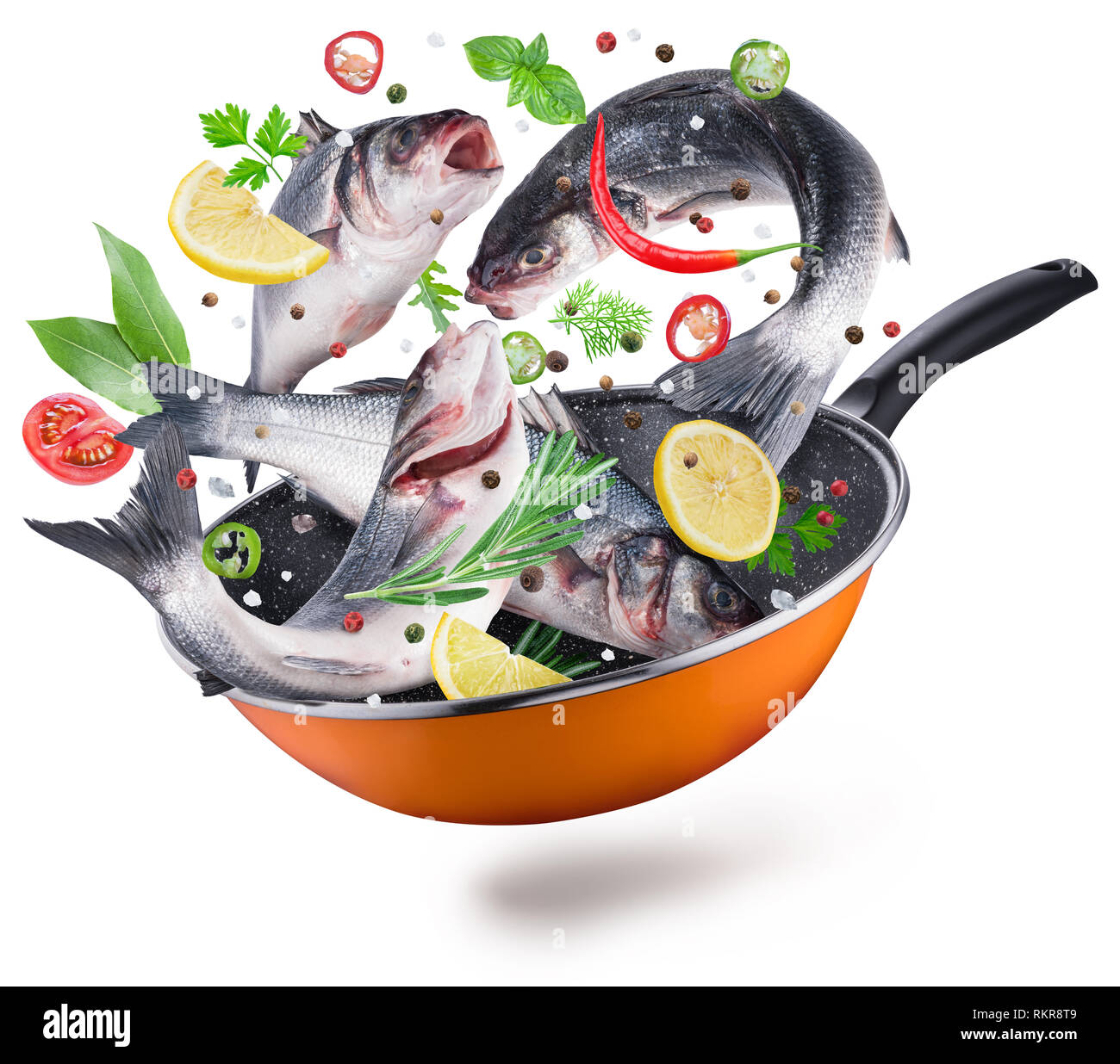 Flying seabass fishes and spices falling into a frying pan. Flying ...