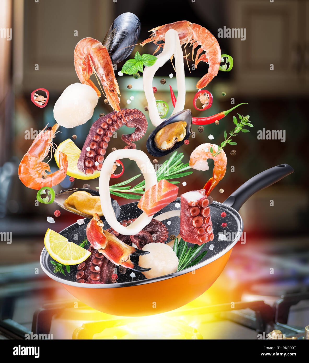 Flying seafood and spices falling into a frying pan. Flying motion ...
