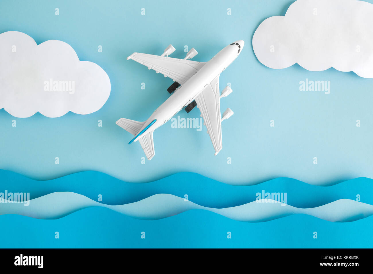 Flat lay of airplane model with sea waves and clouds made of paper ...