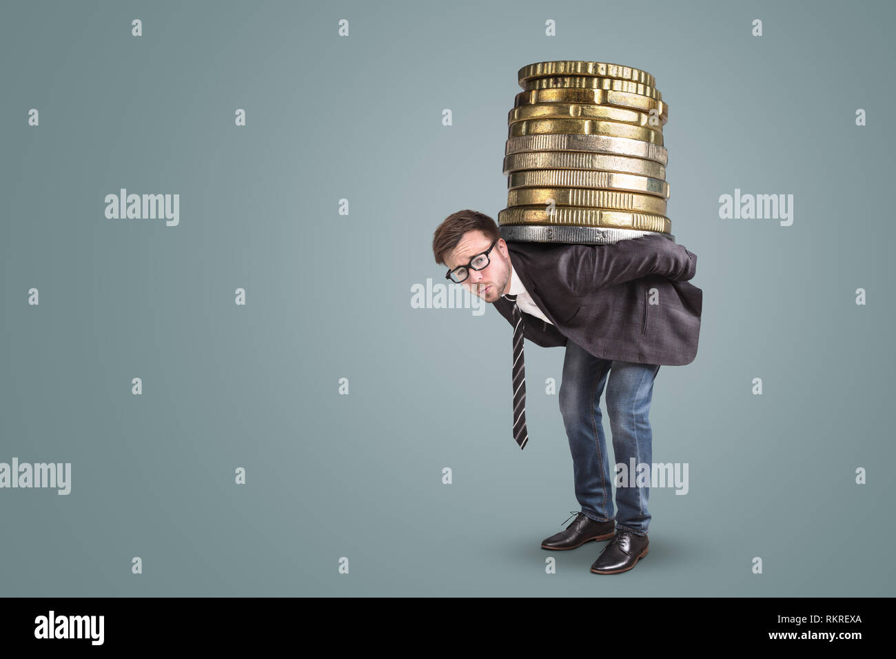 Businessman carrying a giant stack of coins on his back Stock Photo - Alamy