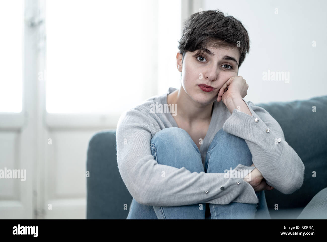 Beautiful desperate and depressed young woman on sofa feeling sad ...